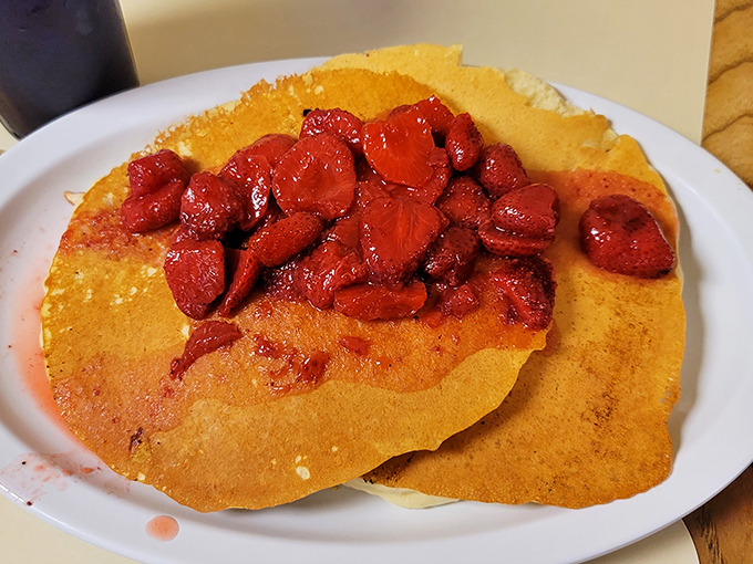 Pancakes topped with strawberries so vibrant they look like edible rubies—the perfect sweet counterpoint to all that savory goodness.