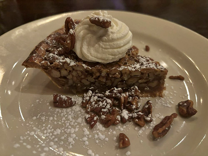 This isn't just pecan pie – it's a sweet geometry lesson in perfection, where every nutty bite is balanced by a cloud of whipped cream and a dusting of powdered sugar.