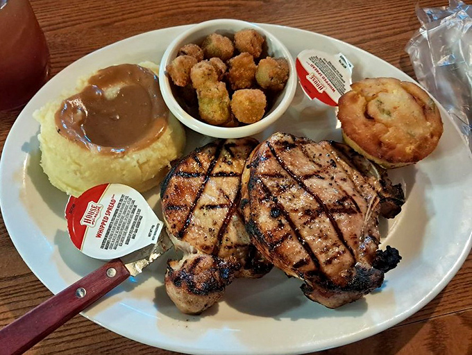 Pork chops with grill marks so perfect they deserve their own Instagram account. That mound of mashed potatoes isn't just a side—it's a gravy reservoir.