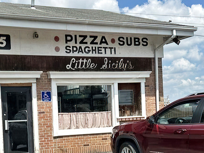 The sign says everything you need to know – no fancy font tricks or buzzwords, just the honest promise of pizza, subs, and spaghetti.