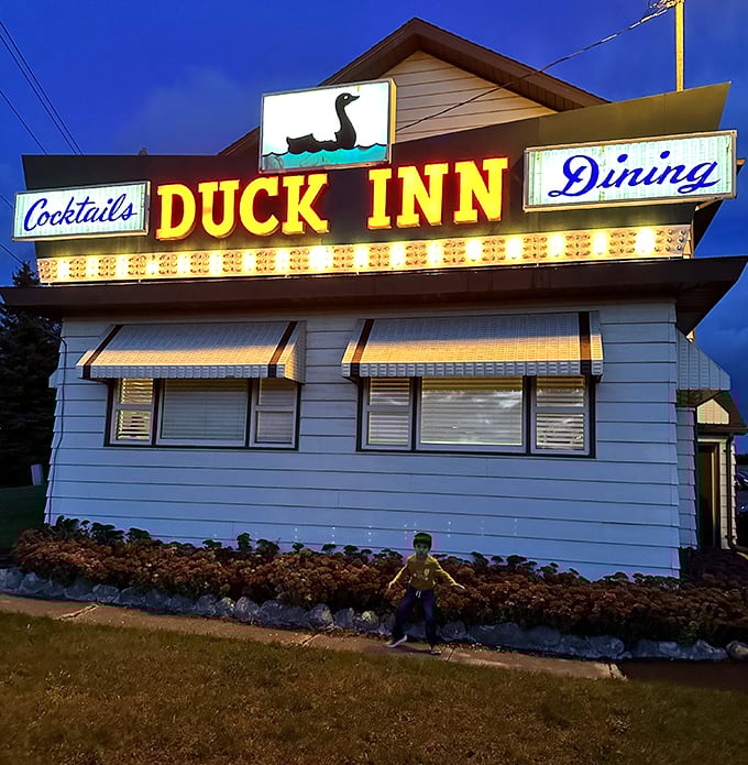 That neon sign against the twilight sky – a beacon of culinary promise that's guided hungry travelers for generations. Resistance is futile.