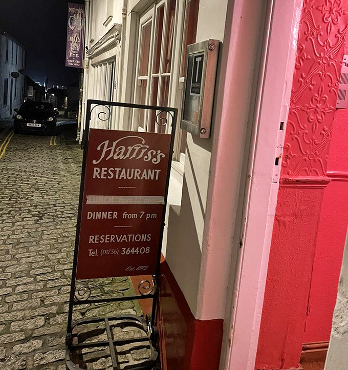 The sign promises exactly what awaits inside: a proper dinner at a proper hour, with reservations strongly encouraged for good reason.