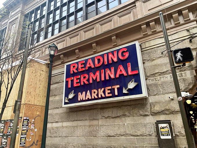 The Reading Terminal Market sign stands as Philadelphia's culinary lighthouse, guiding hungry souls to a historic marketplace where flavor trumps pretense.