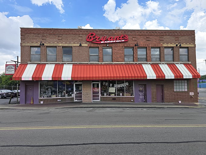 The striped awning and brick facade aren't trying to impress anyone—they don't need to when what's inside has already achieved barbecue immortality. 