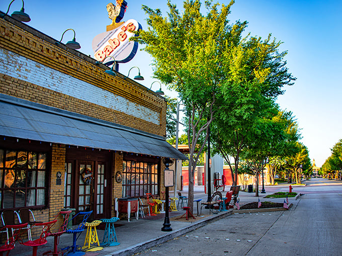 That neon sign isn't just decoration—it's a beacon of hope for the crispy-chicken deprived. Classic brick storefront with colorful chairs just waiting for you.