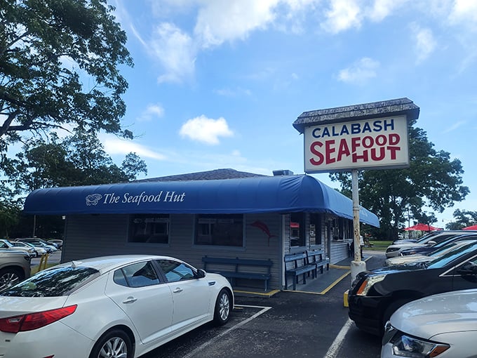 The iconic blue awning of Calabash Seafood Hut beckons like a coastal lighthouse. Simple outside, seafood magic inside!
