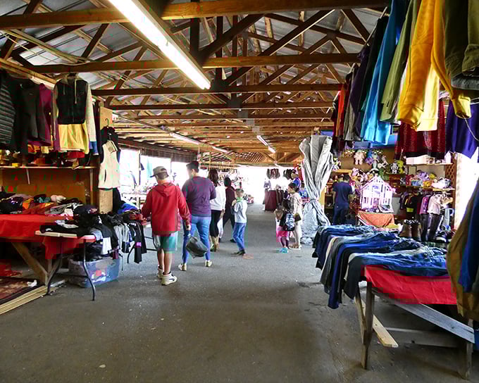 Shoppers navigate a treasure-filled corridor at Jamestown Flea Market, where wooden beams frame a bargain hunter's paradise.