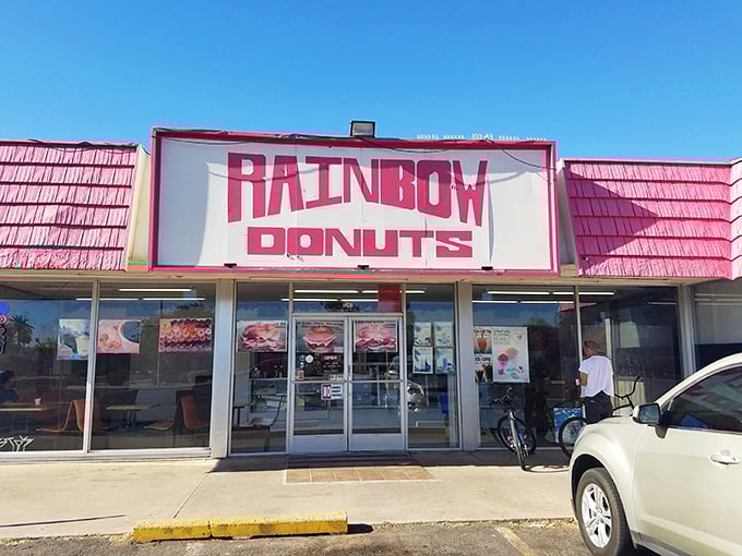 That iconic pink roof and bold "RAINBOW DONUTS" sign – like a beacon of fried dough happiness calling you home.
