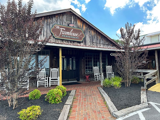 The Farmhouse Restaurant's weathered wooden exterior promises authentic country cooking. Those rocking chairs aren't just for show—they're for savoring the anticipation.