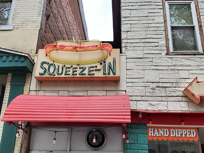 The Squeeze-In's vintage neon hot dog sign promises exactly what you need – a delicious reason to squeeze into this tiny Sunbury landmark.