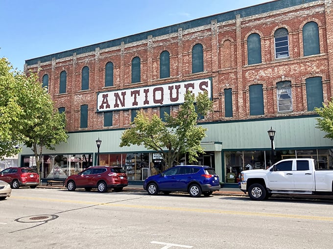 That "ANTIQUES" sign isn't just advertising—it's a siren call to treasure hunters. This brick beauty houses more stories than your grandpa after his third cup of coffee.
