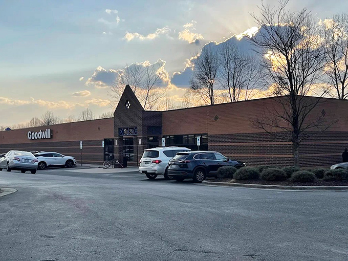 As dusk approaches, this Goodwill transforms into a beacon for bargain hunters. The distinctive peaked entrance welcomes shoppers seeking after-work deals.