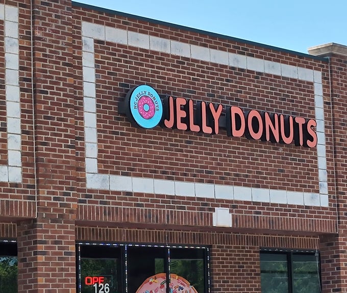 That iconic pink donut logo says it all—life's too short for bad pastries. Jelly Donuts' cheerful storefront makes morning commutes bearable.