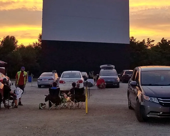 Sunset at South Drive-In creates that perfect golden-hour glow. Families setting up chairs between cars—modern tailgating with a Hollywood twist!
