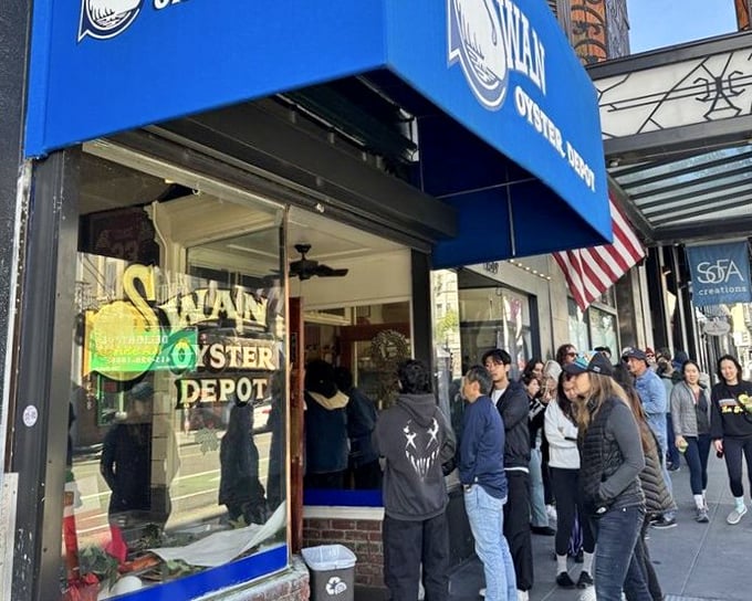 Blue awning, American flag, and a crowd of hungry patrons—Swan Oyster Depot's exterior promises seafood treasures worth the wait.