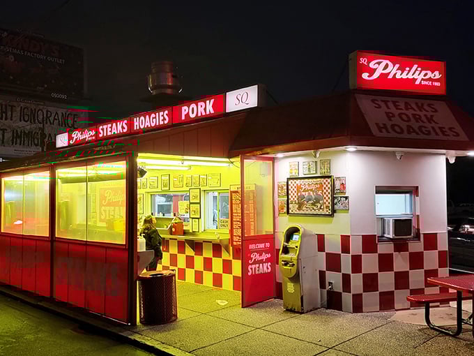 Night falls, but Philip's neon glow promises salvation for late-night cravings. The red and white checkerboard pattern is a culinary chess move.