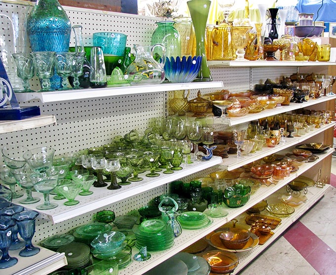 A rainbow of vintage glassware organized by color creates an impromptu art installation. Grandmother's Depression glass meets Mad Men-era cocktail culture in this shimmering display.