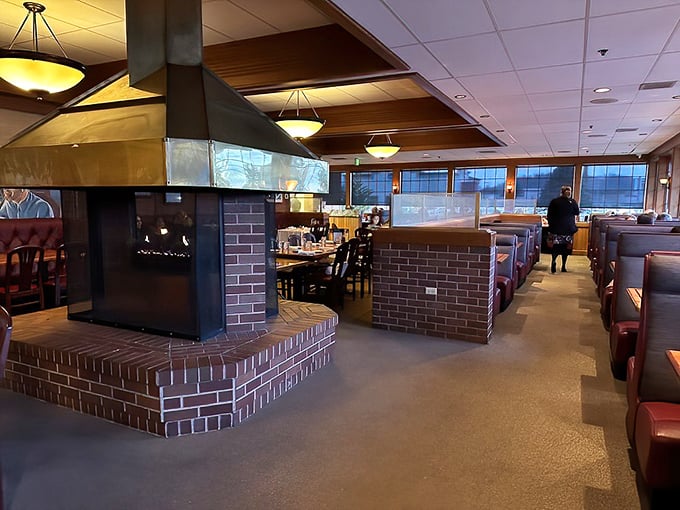 The heart of Sayler's – a cozy fireplace surrounded by burgundy booths where generations of Oregonians have celebrated life's big moments over perfectly cooked beef.