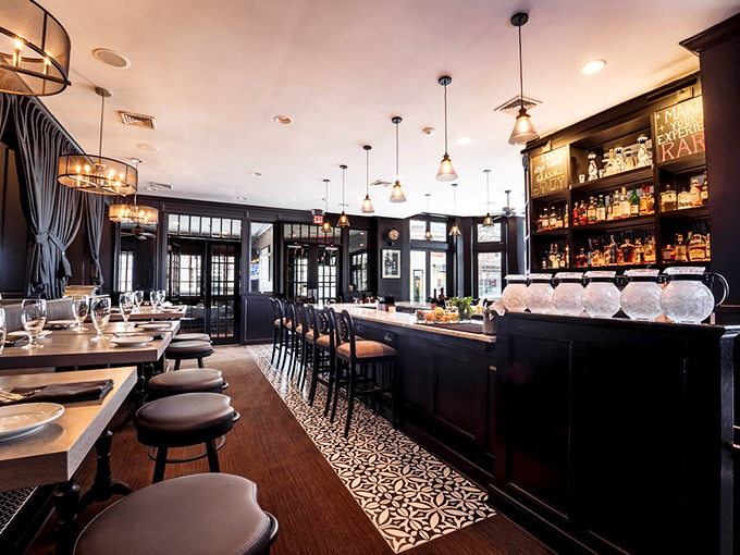 Dark wood, elegant lighting, and a perfectly arranged bar create that rare atmosphere where sophistication meets comfort—like your favorite blazer.