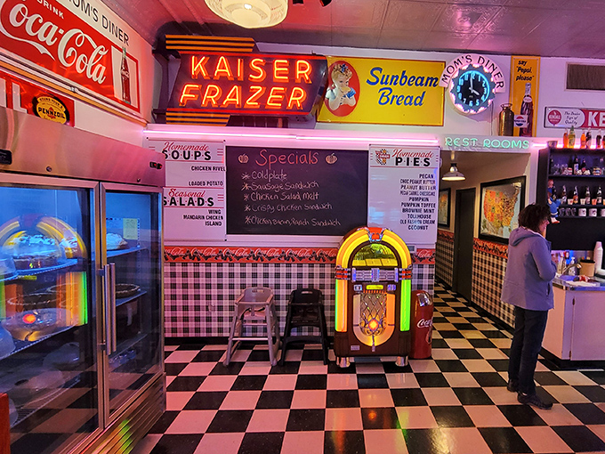 Step inside and the 1950s never ended—checkered floors, glowing neon, and a jukebox that's seen more quarters than a laundromat. The colorful Kaiser Frazer sign reminds us when cars had personality, not just Bluetooth. 