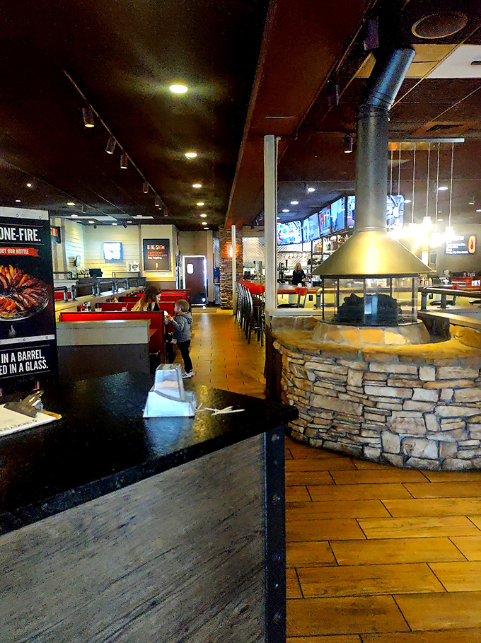 That central stone fireplace isn't just for show—it's the beating heart of the restaurant, a monument to mankind's greatest discovery: cooking with fire.