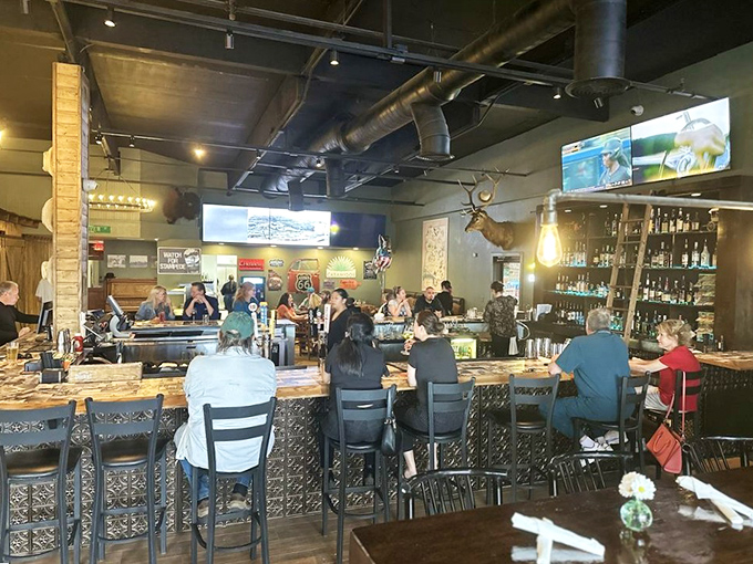 Inside, rustic meets modern with exposed ductwork, mounted deer heads, and a bar that beckons you to pull up a stool and stay awhile.