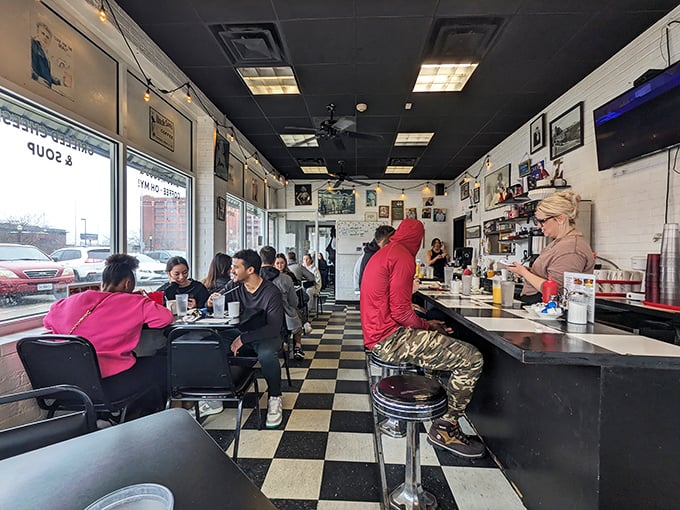 Classic black and white tiles dance beneath your feet while regulars perch at the counter, participating in the timeless ritual of American diner culture.