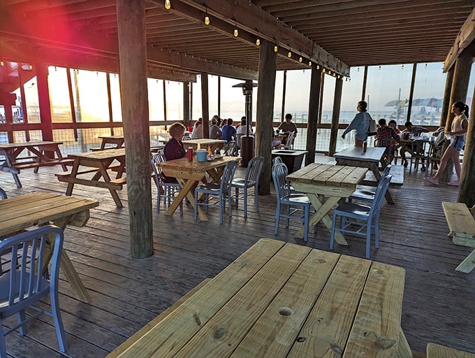 Sunset dining on the deck where wooden tables, blue chairs, and panoramic harbor views combine to create the perfect Florida seafood experience.