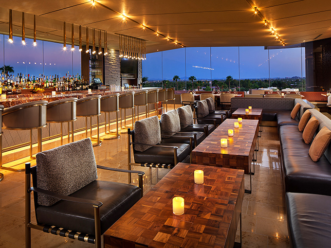 Bar nirvana where amber lighting meets city vistas. The kind of place where James Bond would order a martini and the bartender would already know—shaken, not stirred.