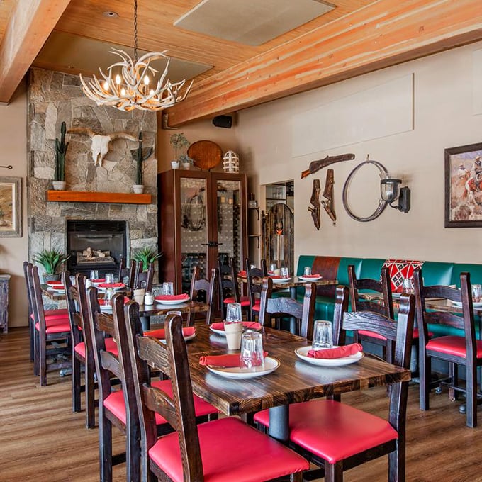Antler chandeliers, stone fireplaces, and those vibrant red chairs – dining rooms don't get more "Sedona" than this cozy corner of cowboy heaven.