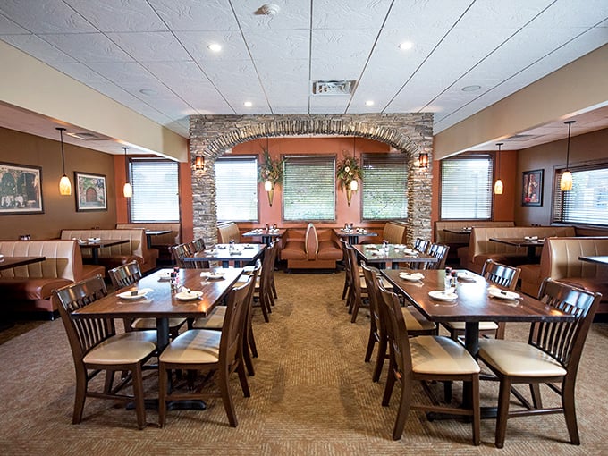 Warm earth tones, stone archways, and thoughtfully arranged tables create that rare dining space that feels both spacious and intimate.