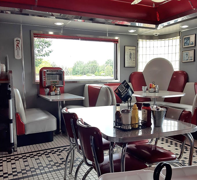 Inside, red vinyl booths and chrome-edged tables create the perfect backdrop for conversations that flow as easily as the coffee refills.