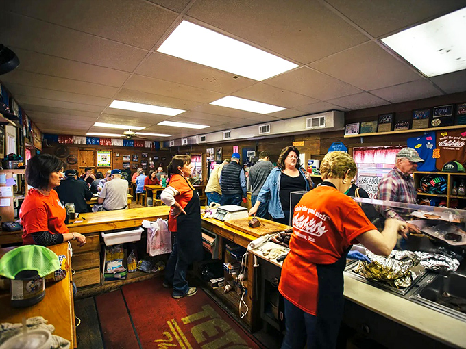 Inside Snow's, the ordered chaos of a bustling barbecue joint unfolds—customers pointing at their selections while staff slice meat with the precision of diamond cutters.
