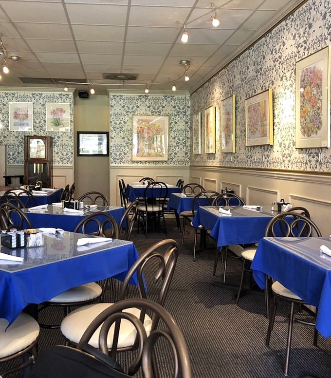 Blue tablecloths and floral wallpaper create that perfect "grandma's dining room" vibe—if grandma happened to be a breakfast wizard with a PhD in comfort.