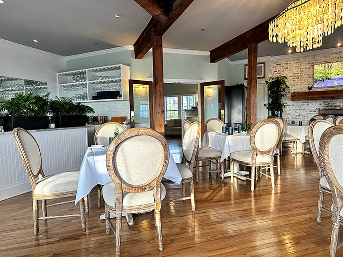 Elegant French-inspired chairs and exposed wooden beams create a dining room that feels both sophisticated and welcoming—like a coastal chateau with Florida flair.