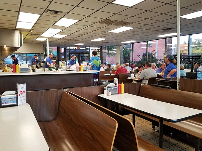 Step inside where wood-grain booths and fluorescent warmth create the perfect backdrop for serious comfort food conversations.