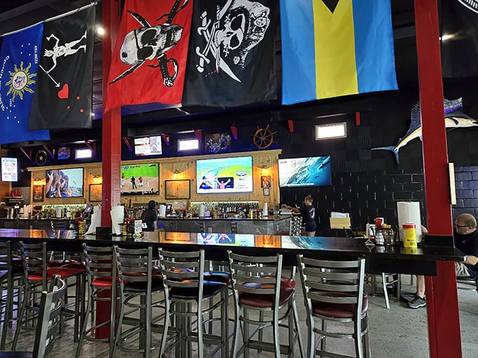 Flags hang like colorful sentinels over a bar that's seen its share of BBQ celebrations. This isn't interior decorating—it's a visual history of good times.