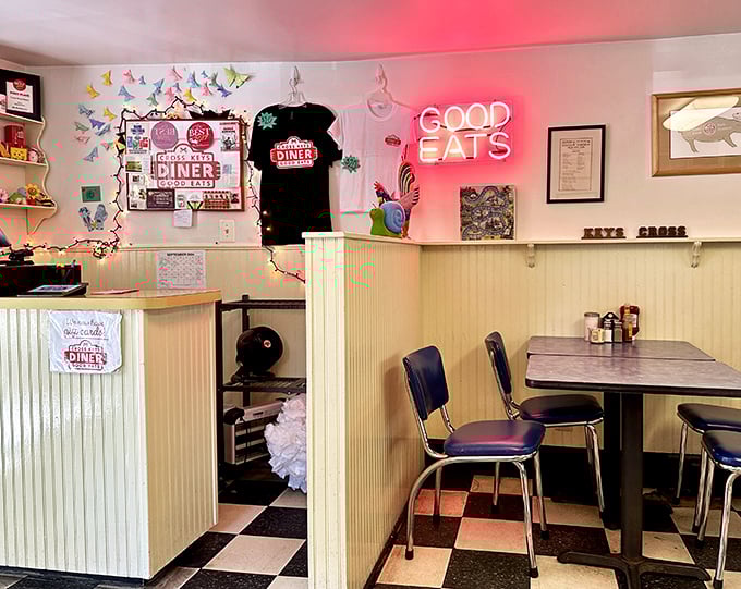 Inside, classic diner charm meets homey comfort with checkered floors, blue vinyl chairs, and that glowing "Good Eats" sign that never lies.