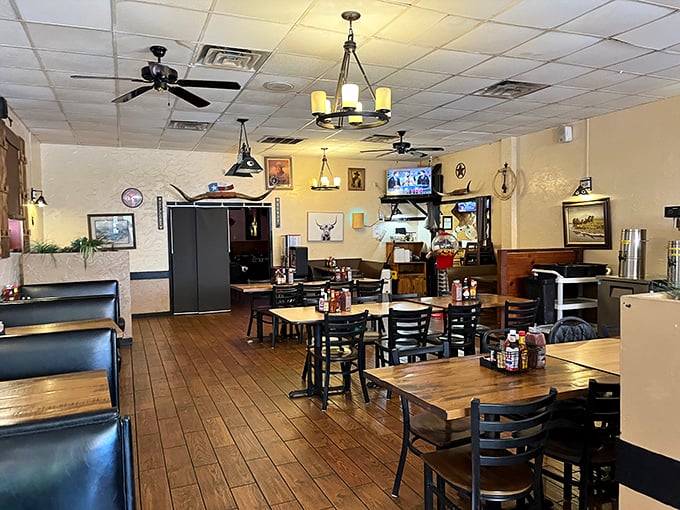 Simple wooden tables, Texas memorabilia, and ceiling fans spinning lazily overhead—this isn't designer ambiance, it's authentic steak house atmosphere at its finest.