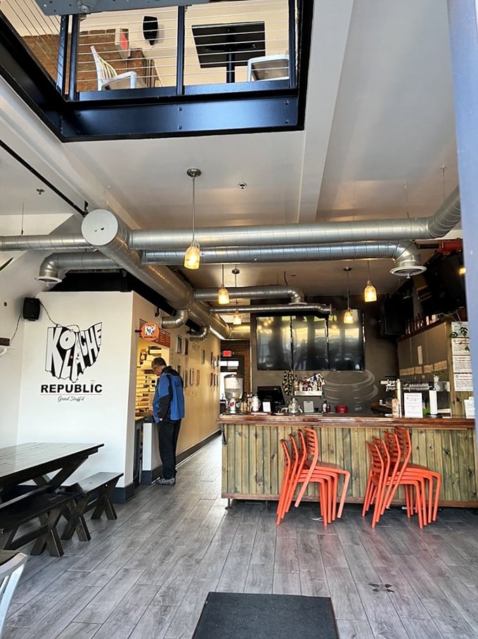Inside, industrial chic meets cozy café. Those bright orange chairs aren't just for sitting—they're your front-row seats to pastry paradise.
