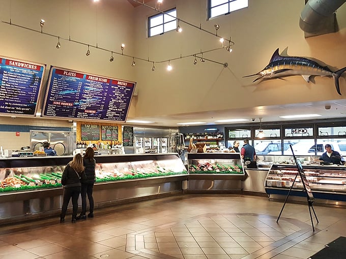 Seafood shopping as theater: gleaming display cases showcase the day's catch while mounted marlins keep watchful eyes on the proceedings below.