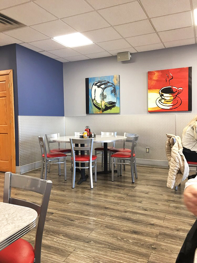 Modern meets nostalgic with blue walls, metallic accents, and breakfast-themed art. The kind of place where coffee tastes better and conversations flow easier.