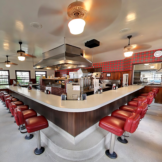 The iconic U-shaped counter where culinary magic happens. Those red stools aren't just seats—they're front-row tickets to burger theater.