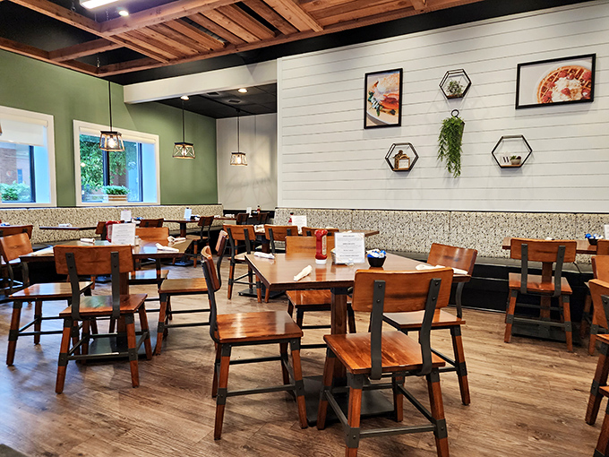 Wooden chairs, green walls, and hexagonal art create a space that's both trendy and comfortable—like if your coolest friend decided to open a breakfast joint.