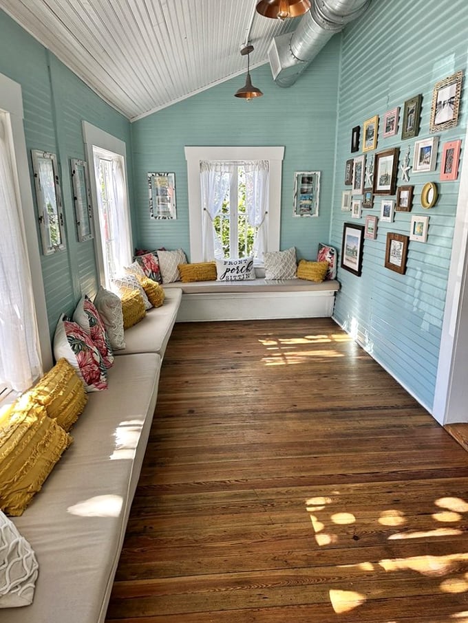 Seafoam green walls, weathered wood floors, and sunlight streaming through white curtains—this waiting area feels like the beach house you've always wanted.