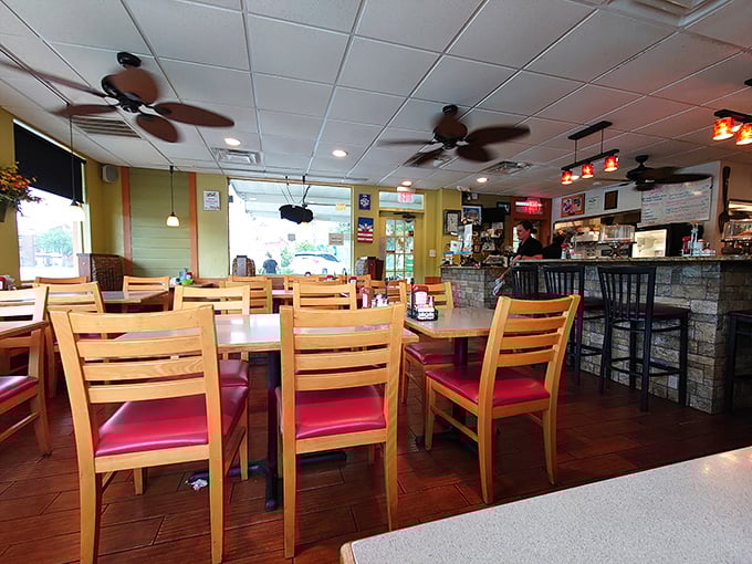 Inside, wooden chairs with cherry-red cushions invite you to settle in for the main event. The ceiling fans lazily spin overhead, as if they too are in no rush to leave.