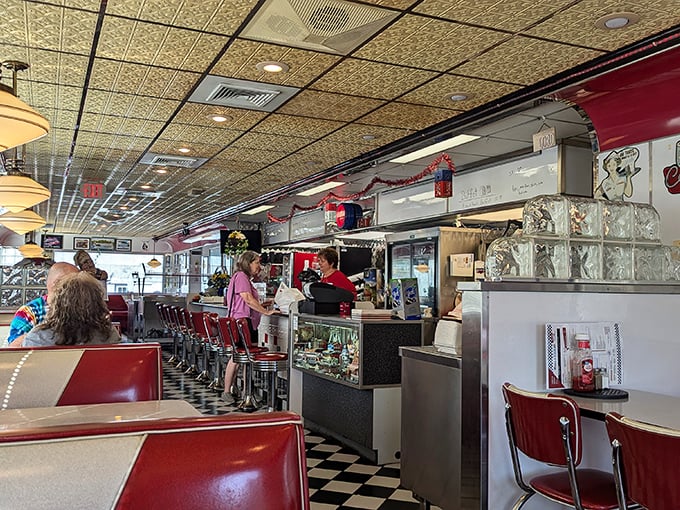 Red vinyl booths and chrome stools await beneath vintage ceiling tiles. This isn't retro-inspired—it's the genuine article that time forgot. 