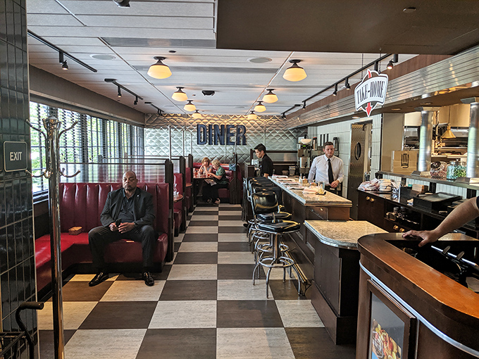 Classic black and white checkered floors meet red leather booths—this isn't just retro-chic design, it's a time machine that serves meatloaf instead of plutonium.
