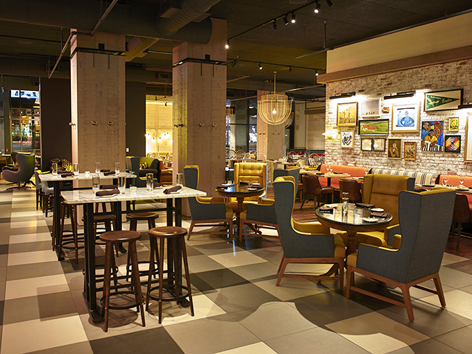 Where rustic meets refined—exposed brick walls and mustard yellow seating create a space that feels both farmhouse chic and metropolitan cool. 