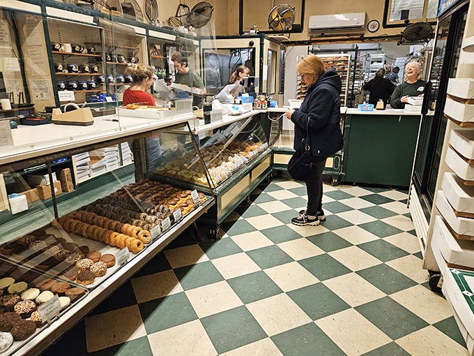 The classic checkerboard floor has witnessed generations of donut devotees debating the eternal question: cream-filled or glazed? Why not both?